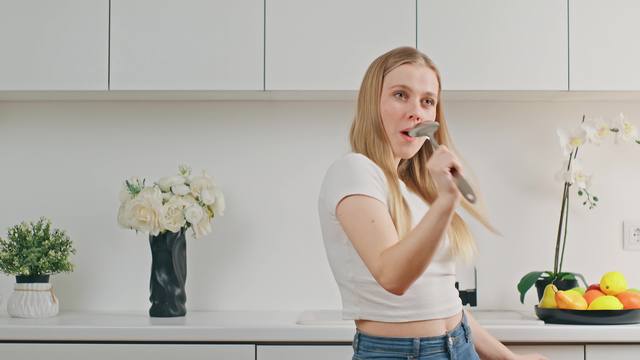 大きなスプーンをマイクにして歌って踊って回転する女性のスローモーションの動画｜無料の動画素材サイト「動画ac」
