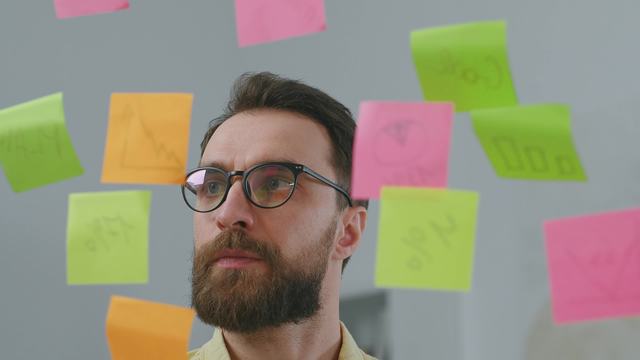 付箋をたくさん貼って考えている男性の動画｜無料の動画素材サイト「動画AC」